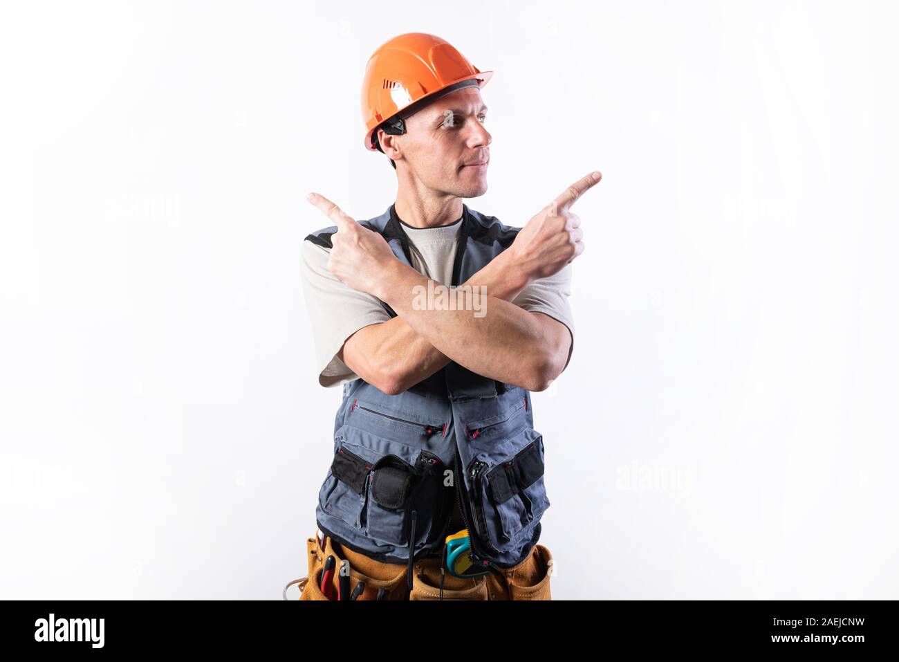 The builder points in different directions. In work clothes and a ...