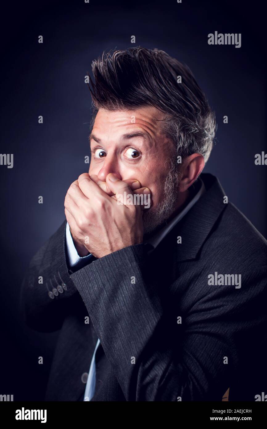 A portrait of funny shocked bearded man with iroquois wearing suit ...