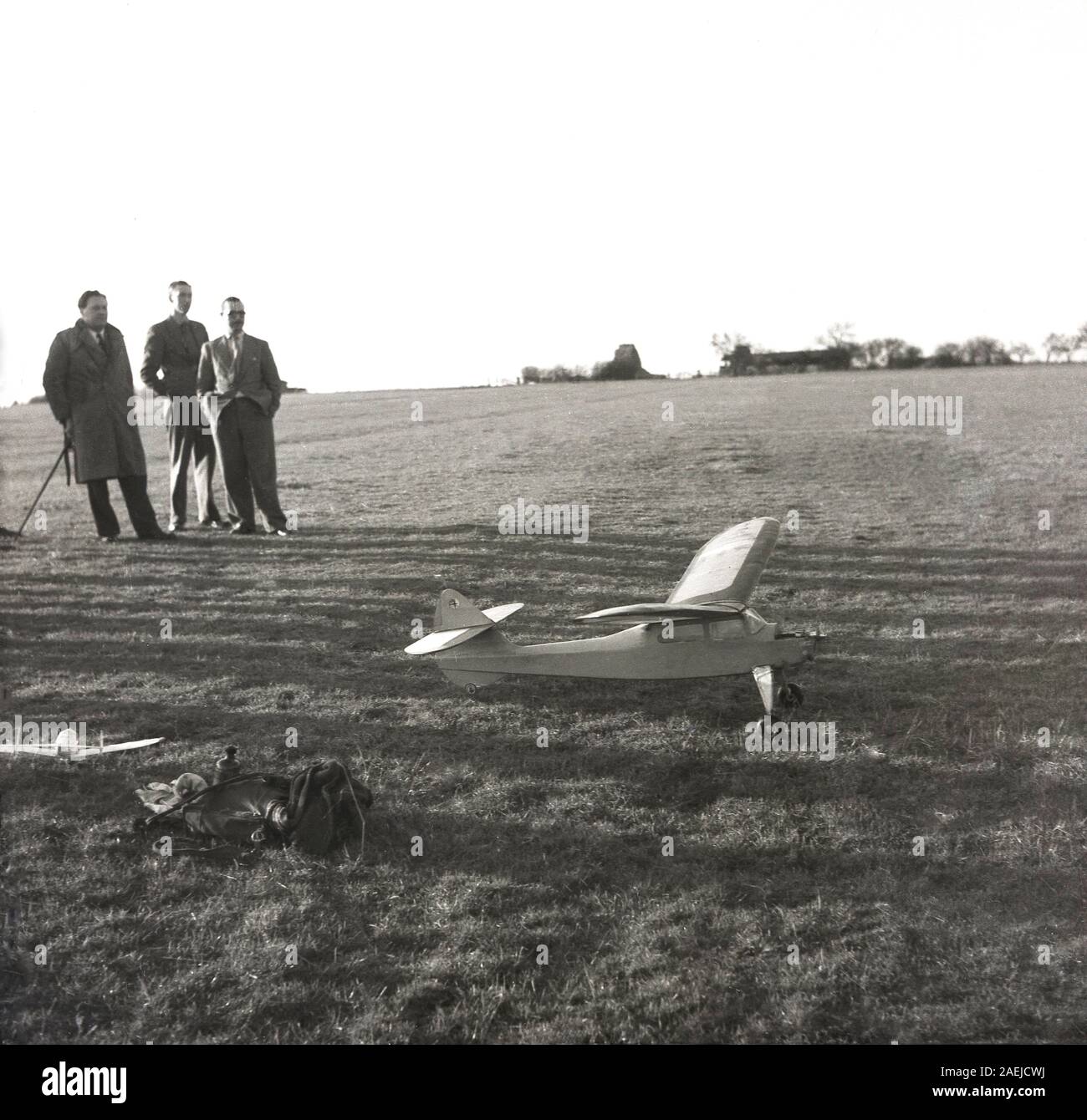 1950s, historical, a flying model aircraft on the ground outside on a ...