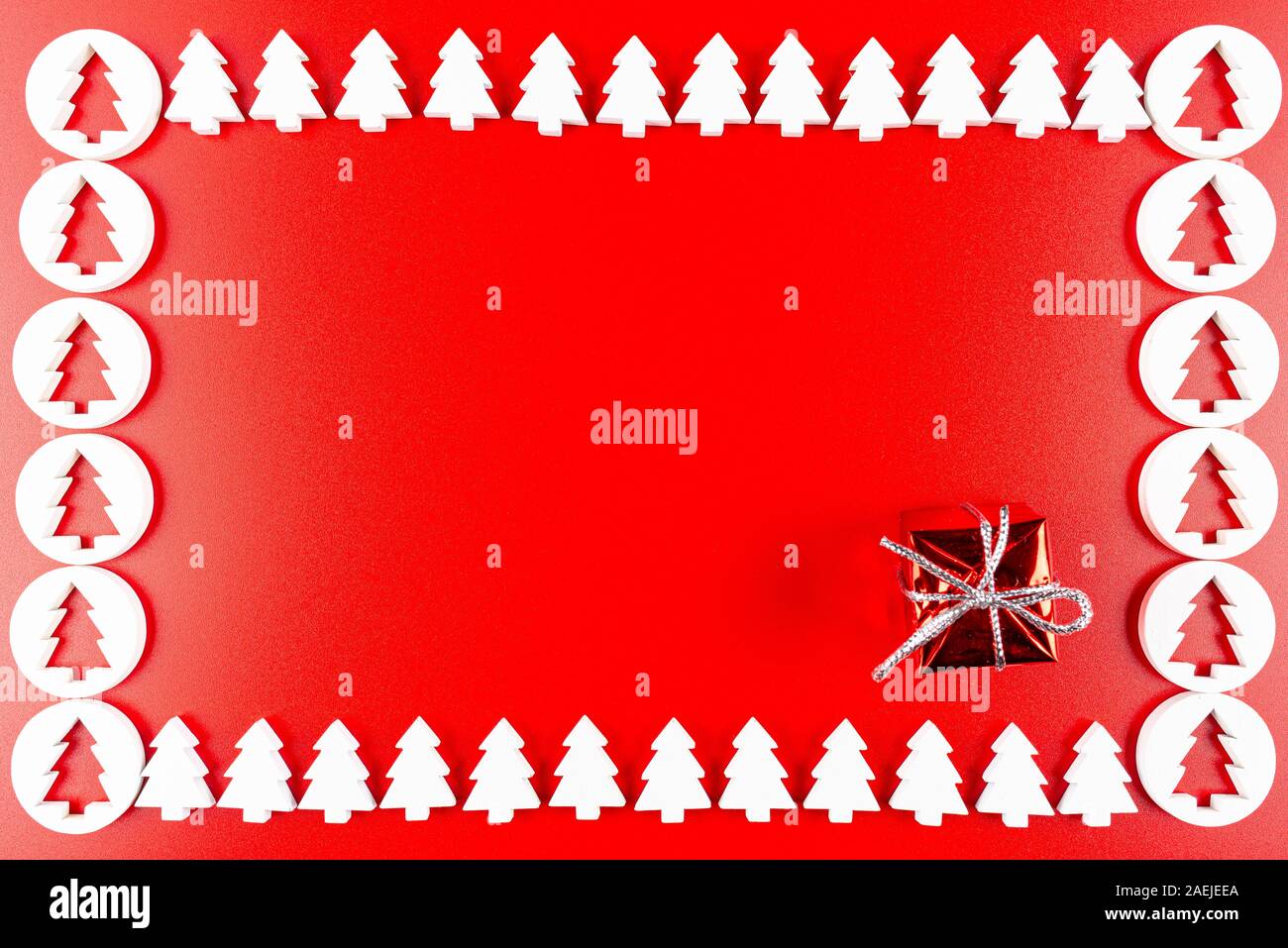 A frame made of white, wooden Christmas trees, wrapped gift in the ...