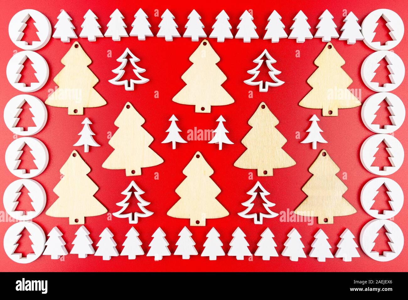 A frame made of white, wooden Christmas trees isolated on a red ...