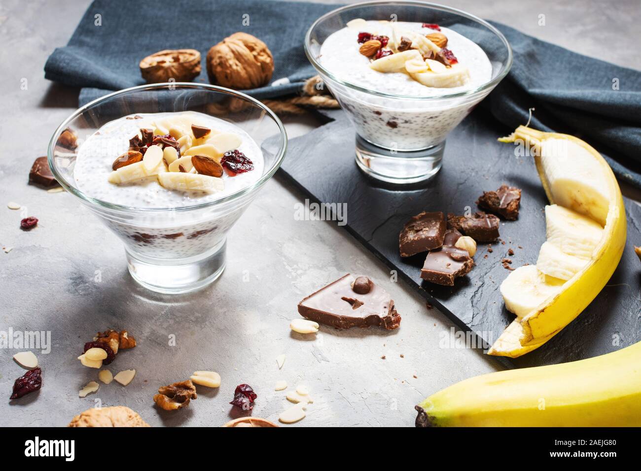 Chia pudding parfait puff with banana, yogurt and nuts on concrete ...