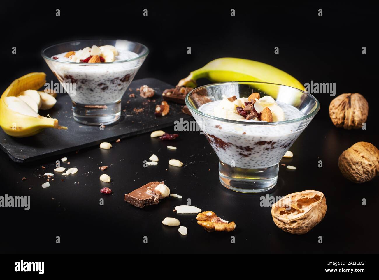 Chia pudding parfait puff with banana, yogurt and nuts on black ...