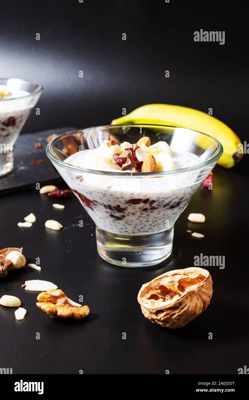 Chia pudding parfait puff with banana, yogurt and nuts on black ...