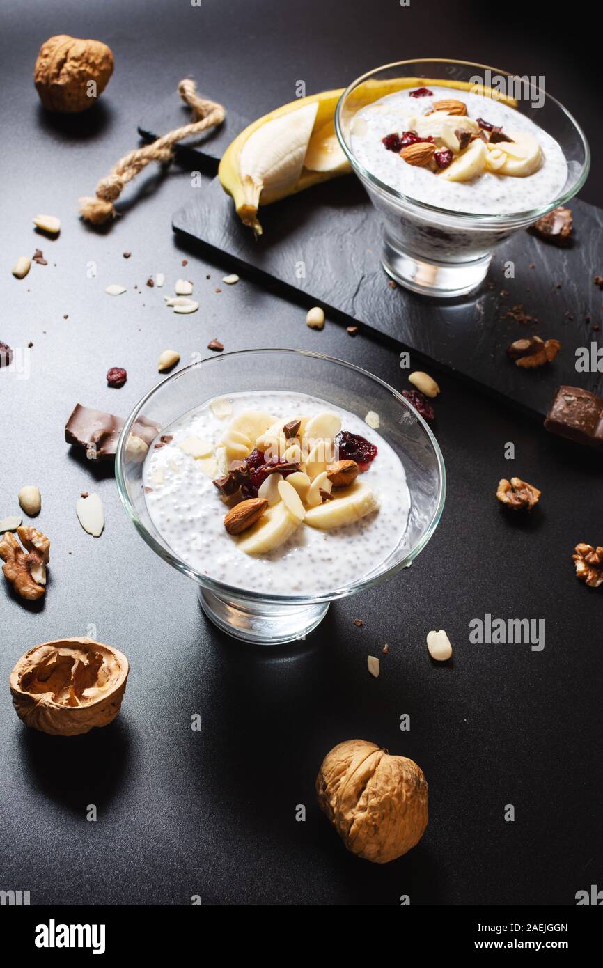 Chia pudding parfait puff with banana, yogurt and nuts on black ...