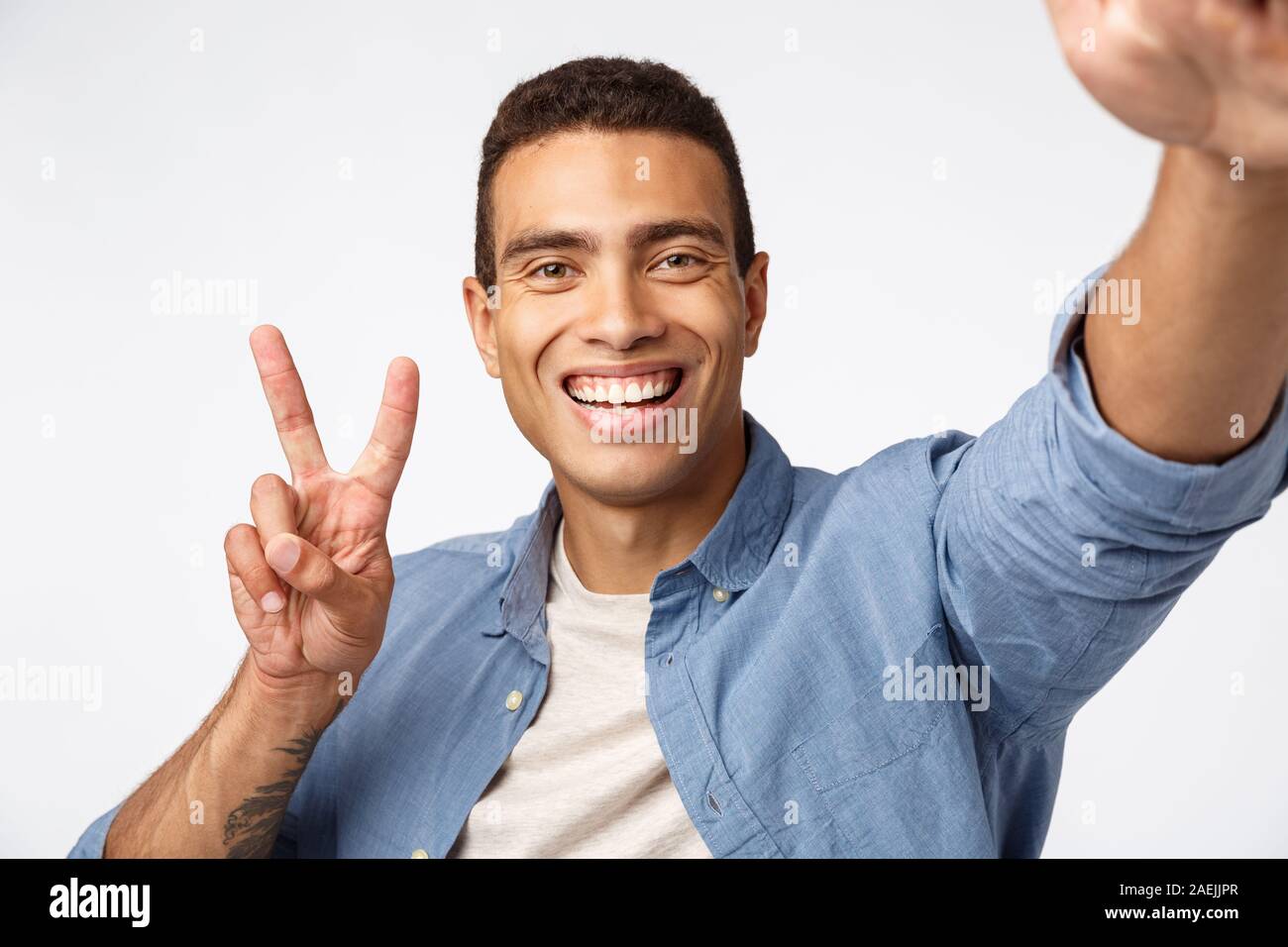 Happy and cheerful friendly man sending positivity, hold camera ...
