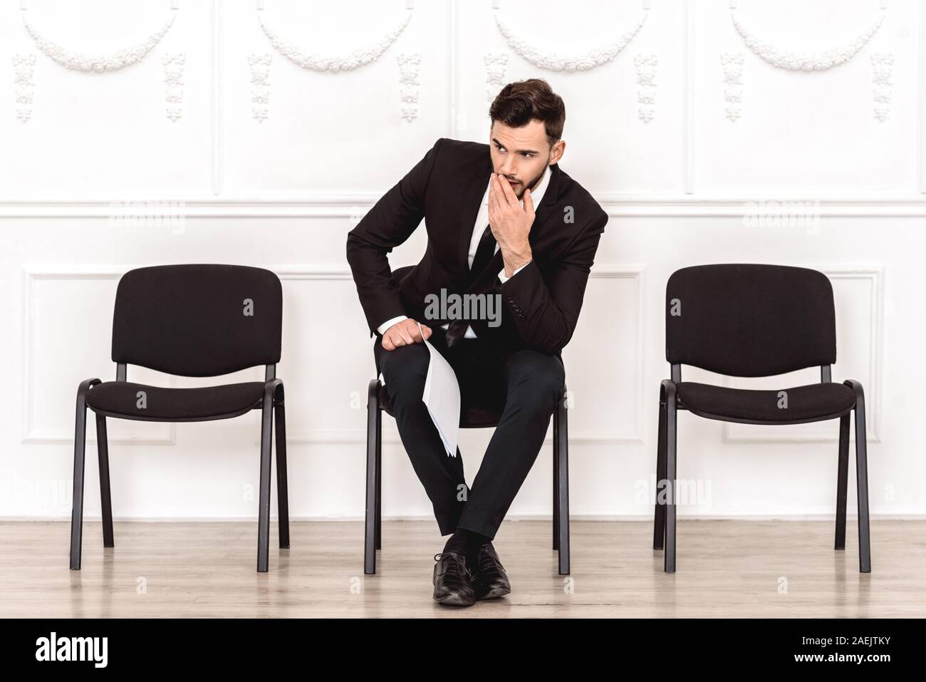 Job interview. Man sitting isolated on white waiting with documents ...