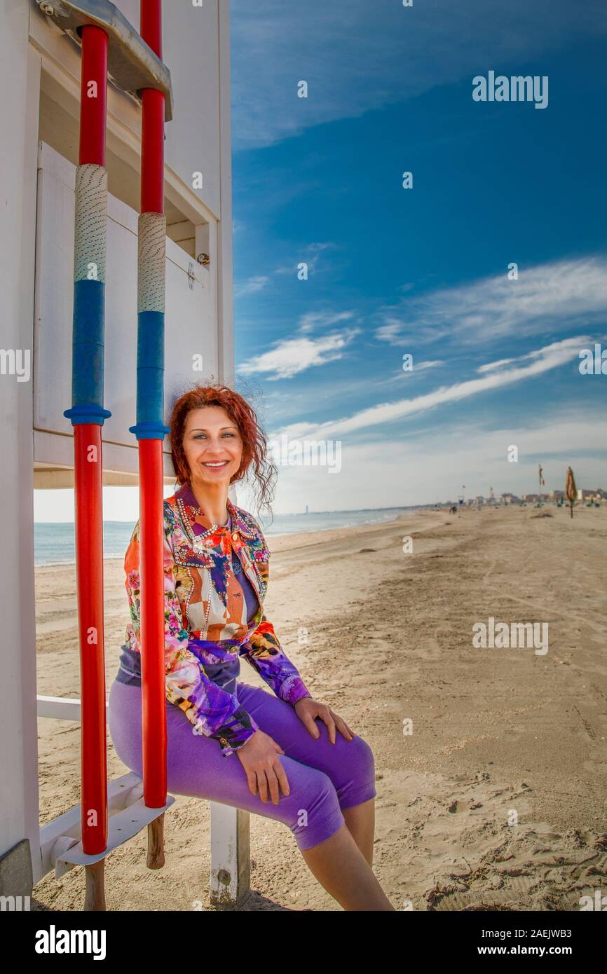 mature woman with mediterranean facial features wearing colorful dress ...