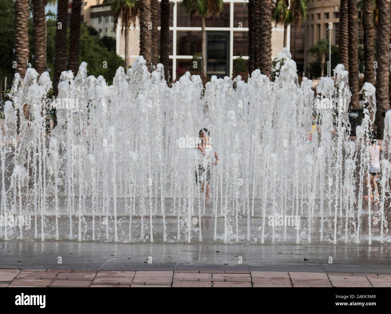 A child is cooling off by running through a fountain at a park in Tampa ...