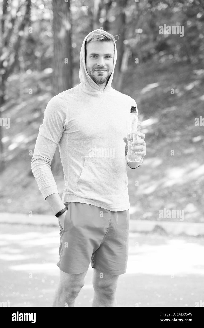 Stay hydrated. Athlete drink water after training in park. Man athlete ...