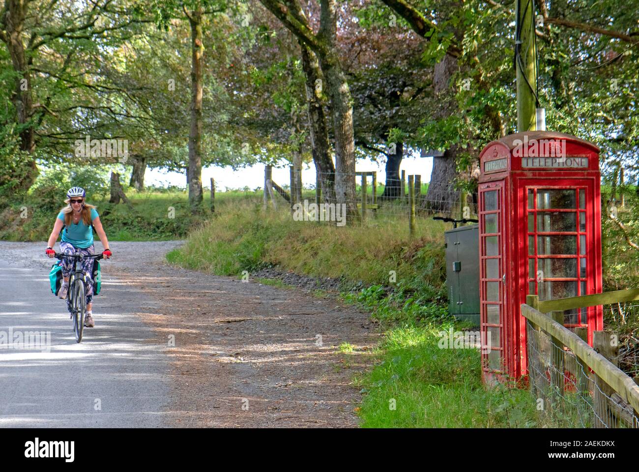 Cyclist passing a phone booth in the Wye Valley, part of the Lon Las ...