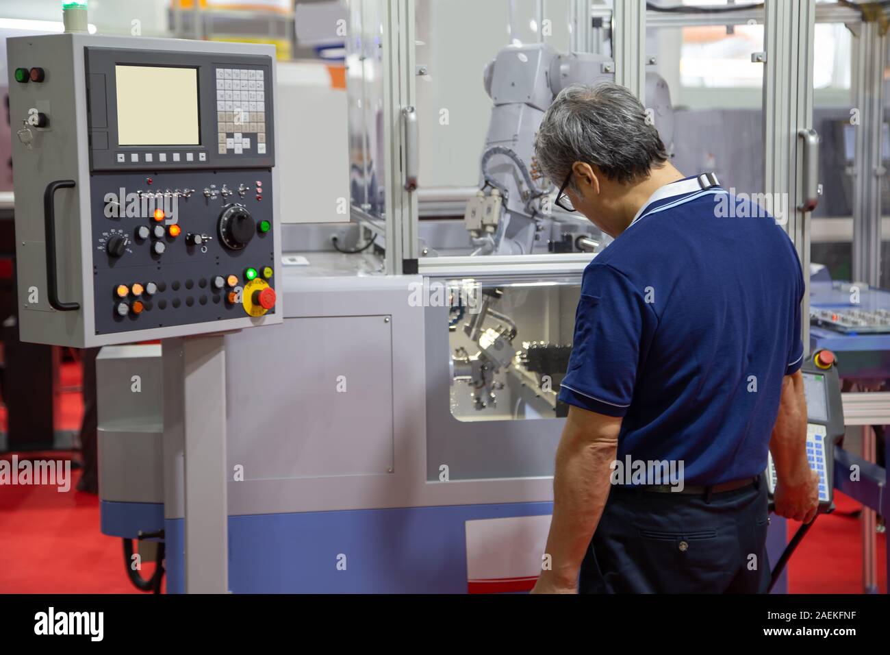 Worker control compact CNC lathe with robotic loading workpiece Stock Photo - Alamy