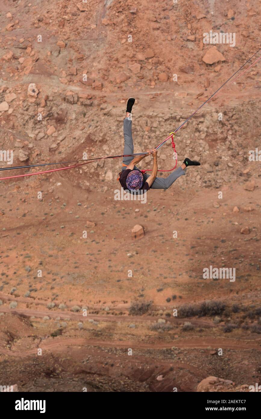A young man loses his balance and falls while slacklining or highlining ...