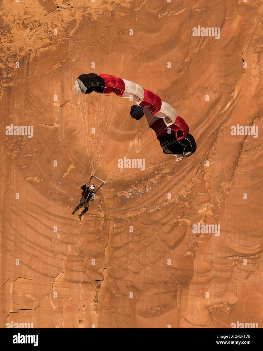 A BASE jumper descends in his parachute off the 400 foot vertical face ...