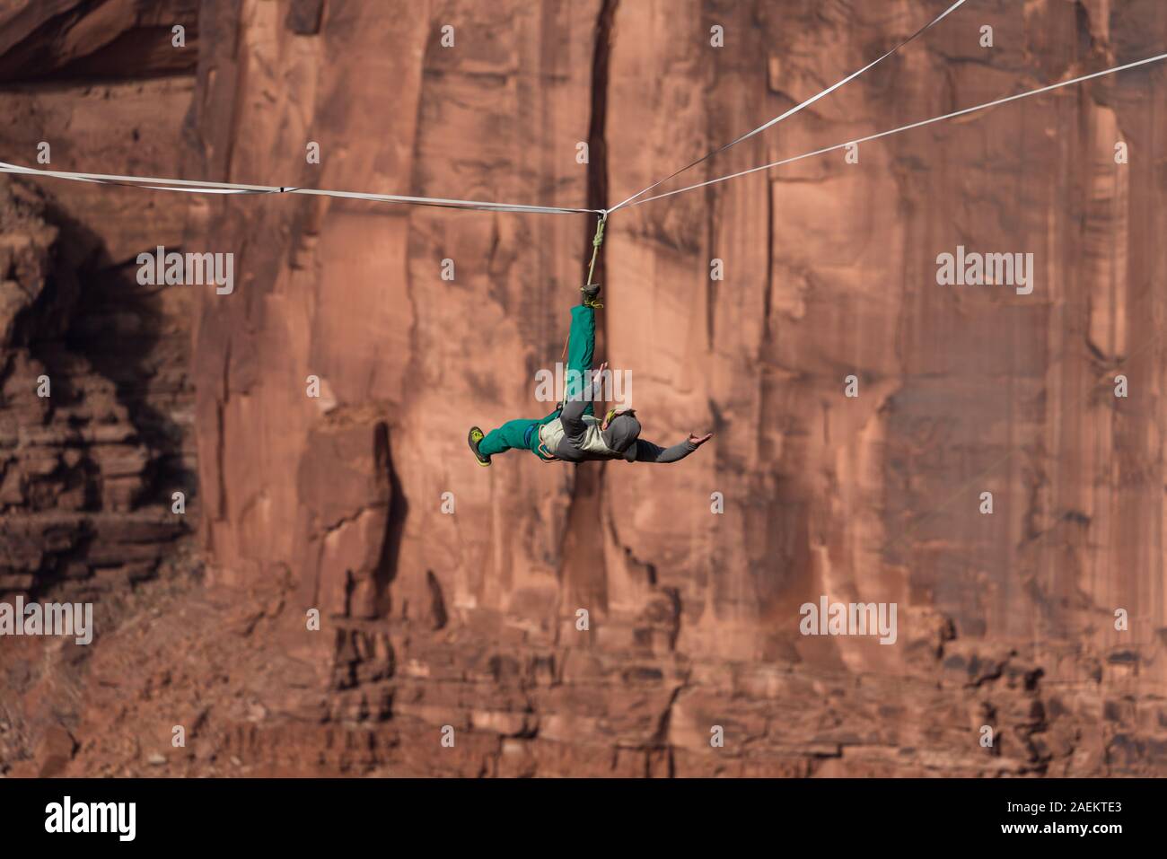 A young man loses his balance and falls while slacklining or highlining ...