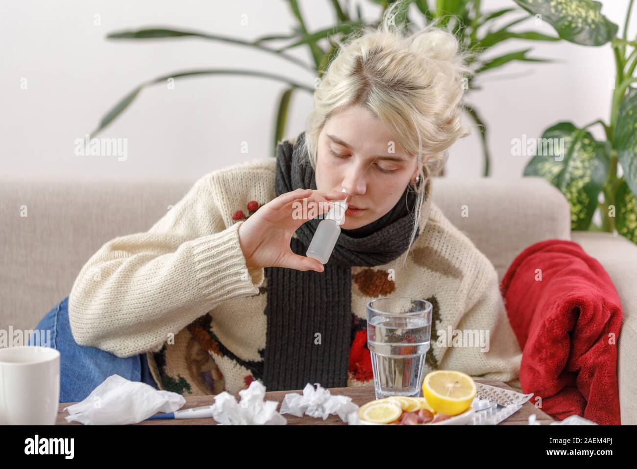 The girl in the sweater is sick lying on the couch. Colds and flu. The ...