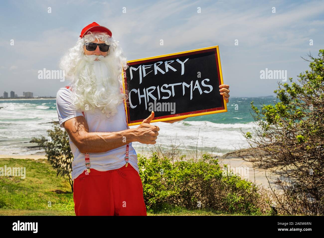 Santa Claus holds gift boxes with the ocean on backgraund. Australia ...