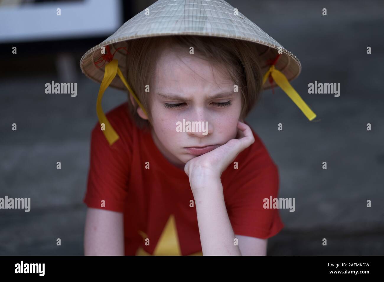 Portrait of a boy in a traditional Vietnamese cone-shaped straw hat ...