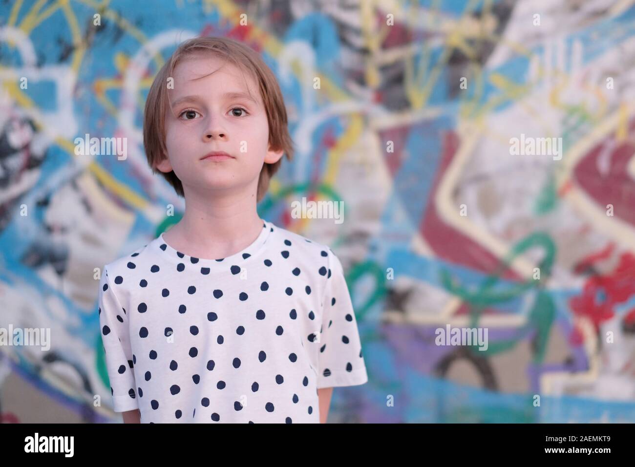 Portrait of a school age child against a wall with graffiti Stock Photo ...