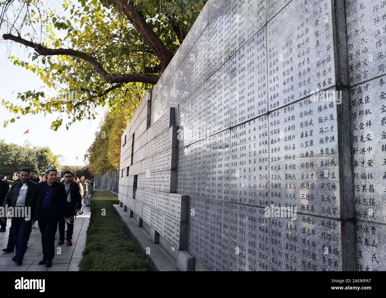 Visitors mourn before the wall upon which there are names of victims ...