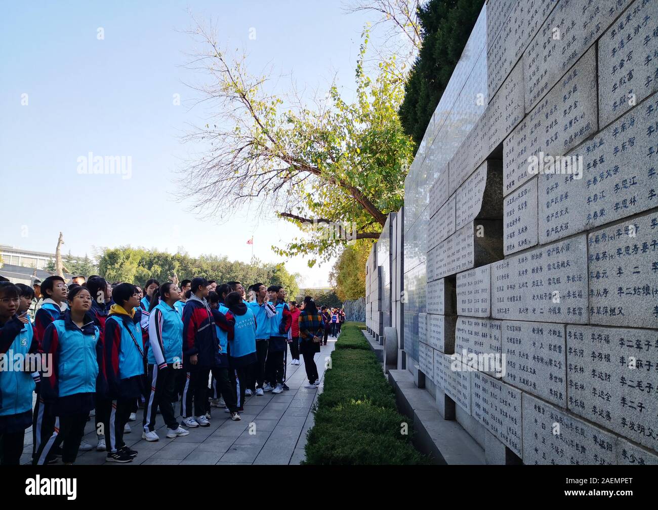 Visitors mourn before the wall upon which there are names of victims ...