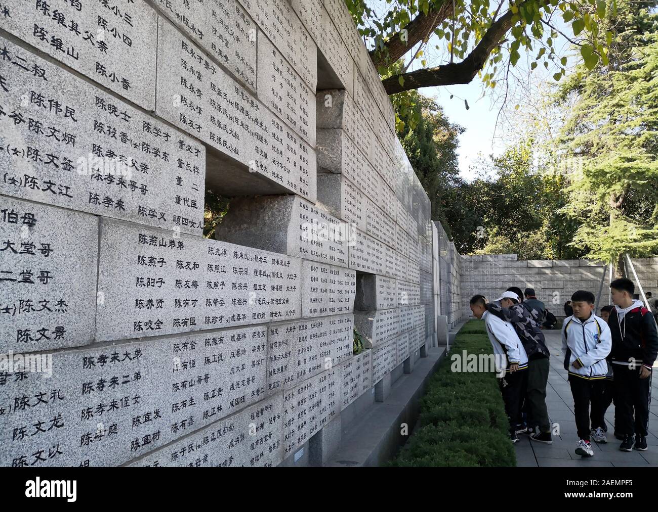 Visitors mourn before the wall upon which there are names of victims ...