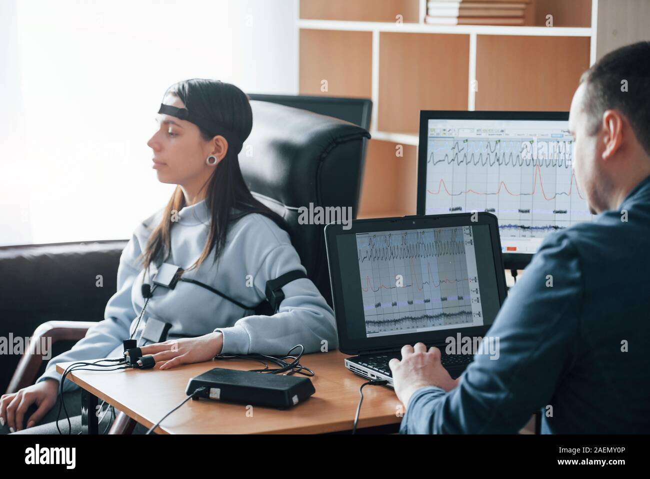 Calm woman. Girl passes lie detector in the office. Asking questions ...