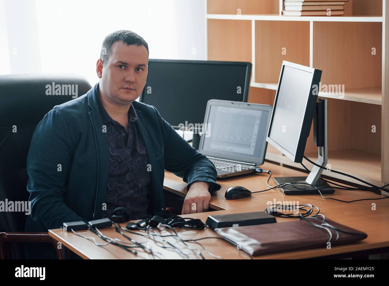 Portrait of professional polygraph examiner in the office with his lie ...
