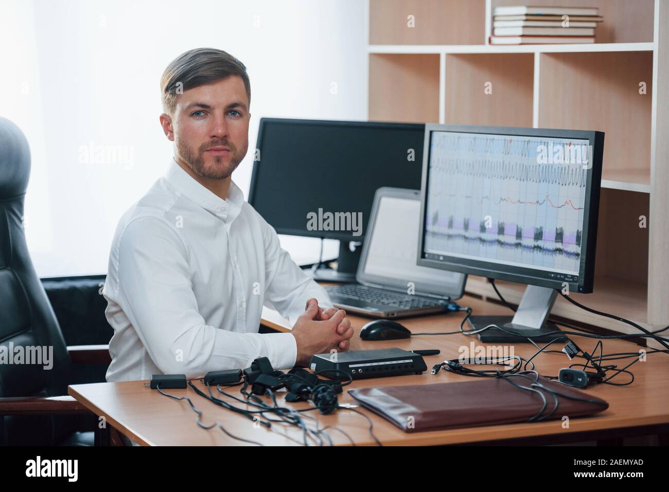 White shirt and many of devices. Polygraph examiner works in the office ...