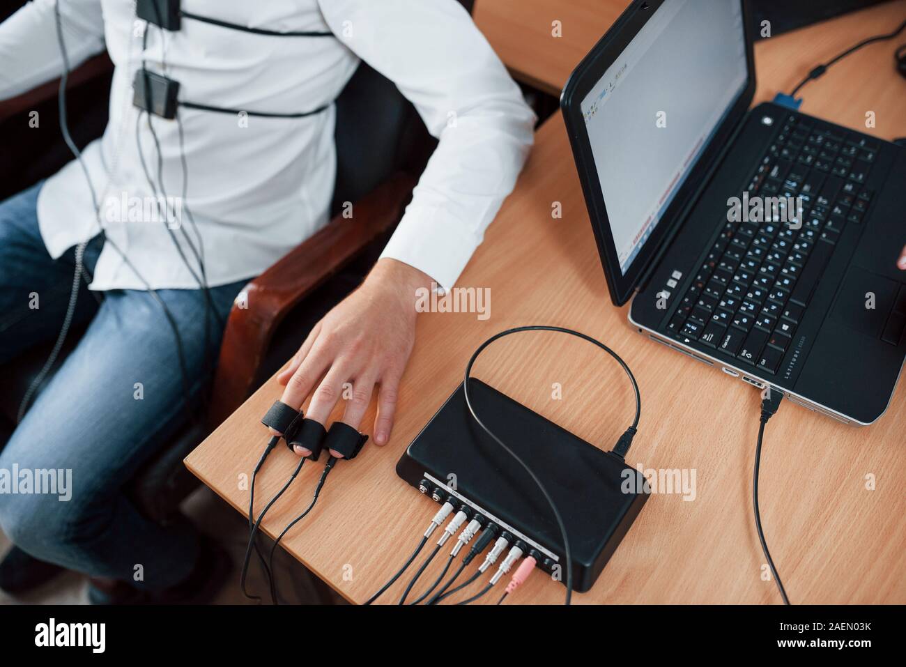 Particle view. Suspicious man passes lie detector in the office. Asking ...