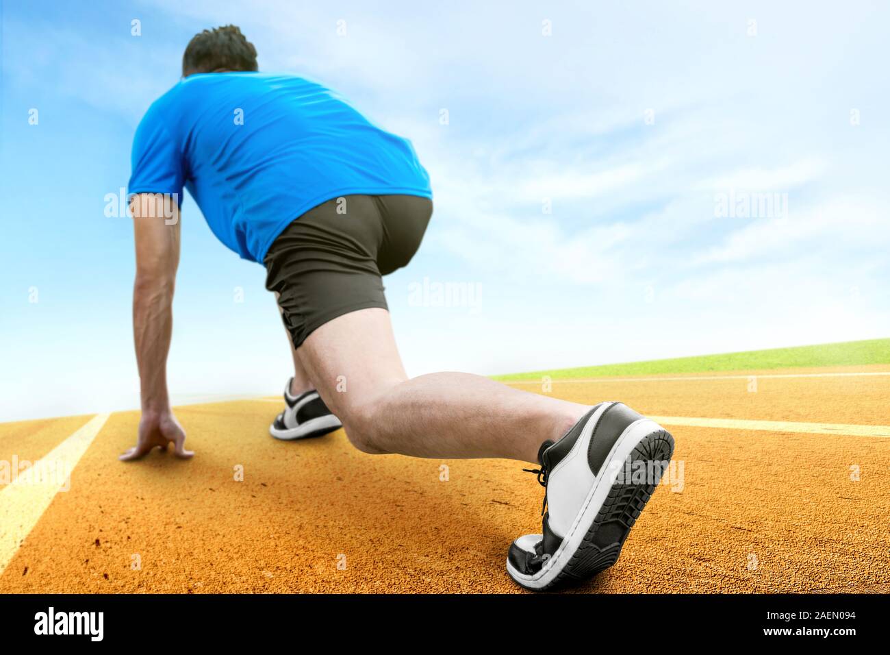 Rear view of Asian runner man ready to run on the running track with a ...