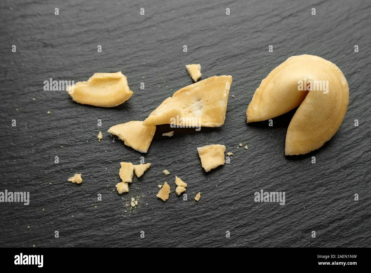 cracked chinese fortune cookie on a black background. place for text ...