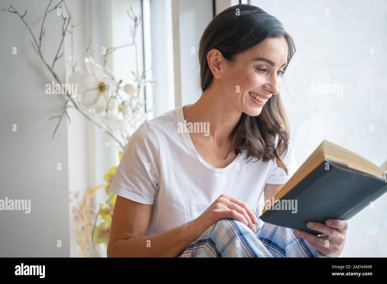Smiling woman reading a funny story stock photo Stock Photo - Alamy