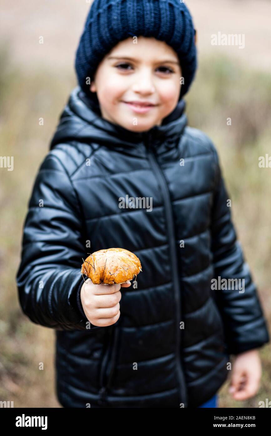 Lttle kid with a mushroom. Focus on mushroom Stock Photo - Alamy