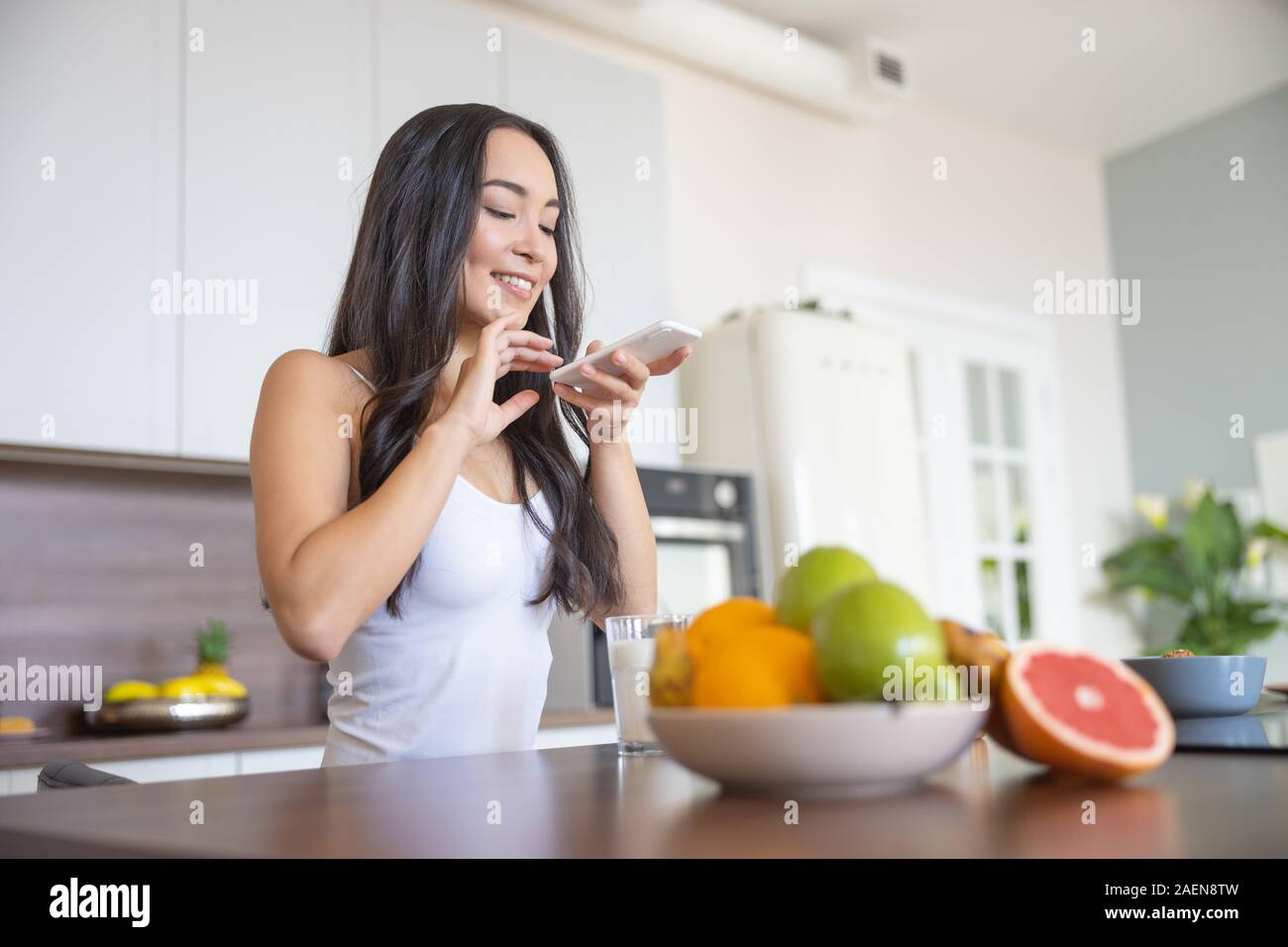 Pleased Asian young woman snapping a photograph Stock Photo - Alamy