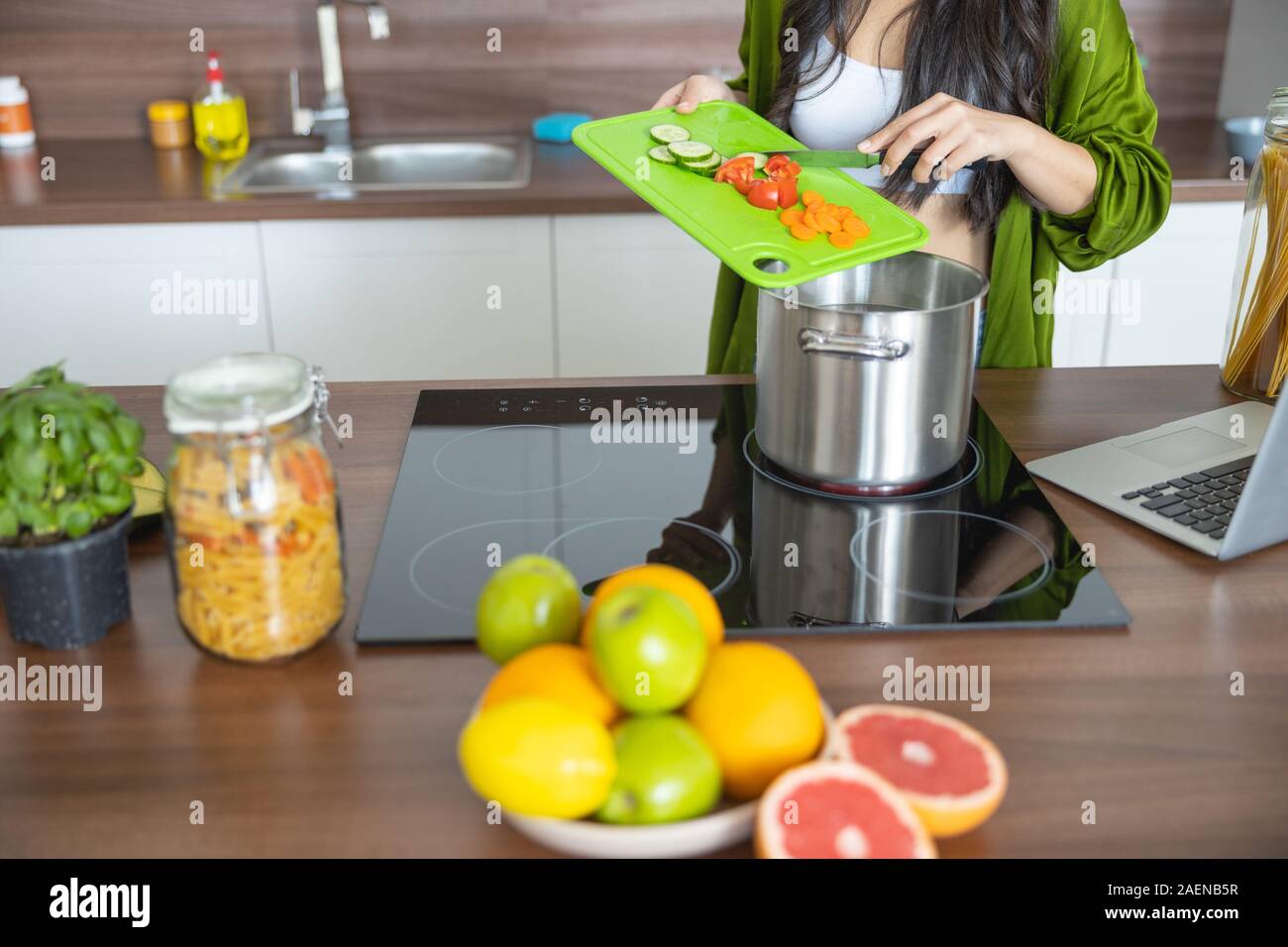 Woman adding vegetables to the cooking pot Stock Photo - Alamy