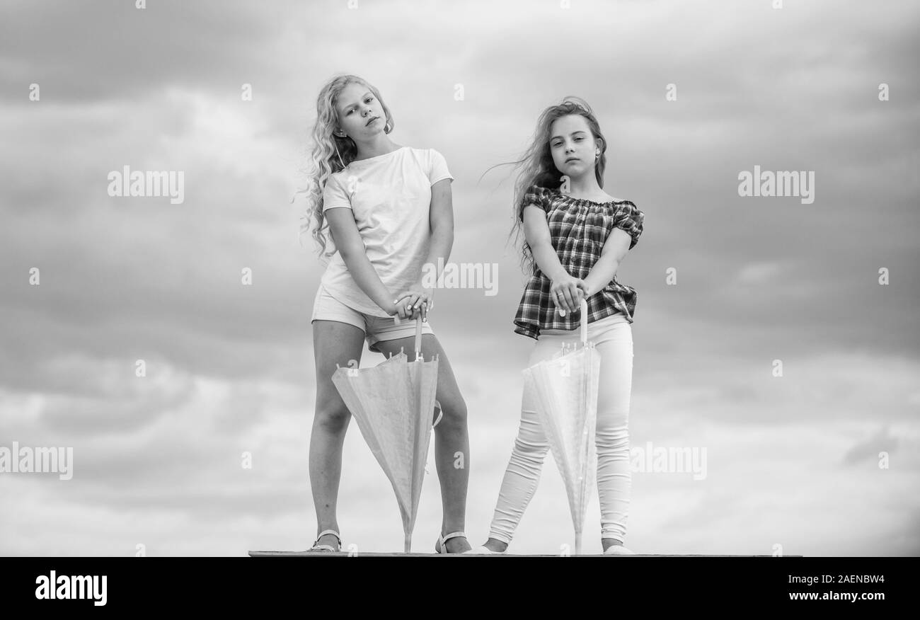 Ready for any weather. Girls friends with umbrellas cloudy sky ...