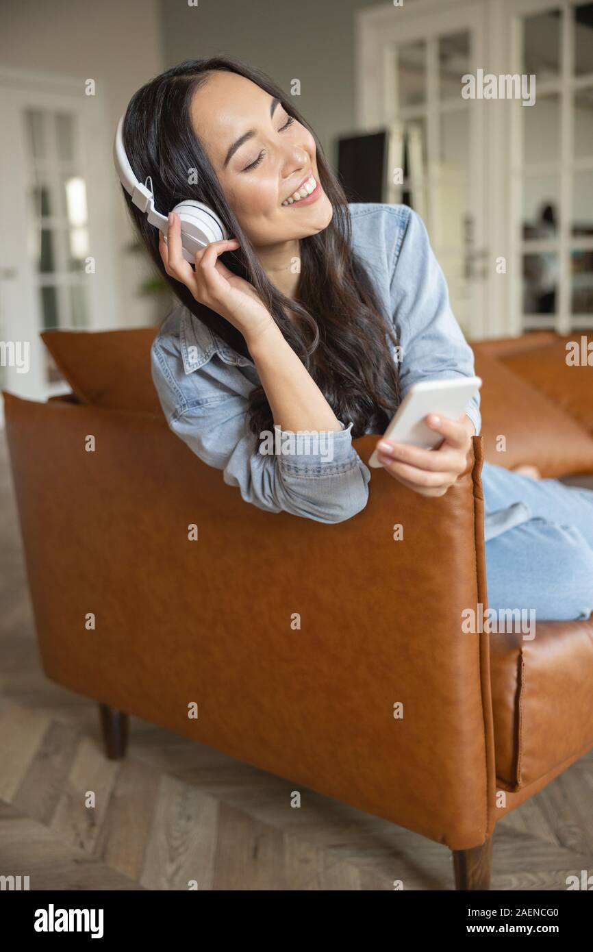 Young female reposing on a leather couch Stock Photo - Alamy