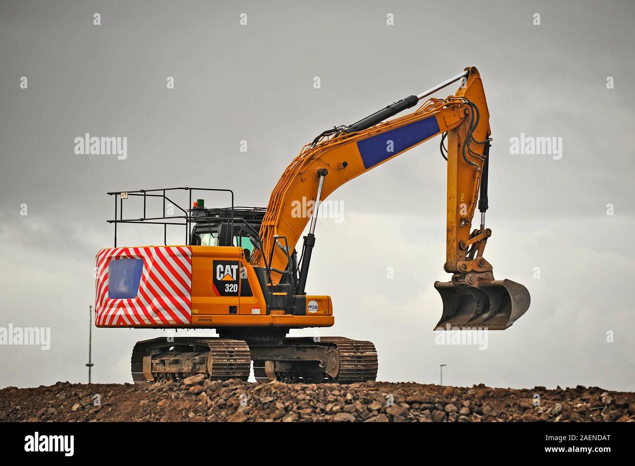 Mechanical digger on mound of earth at new building site set against ...