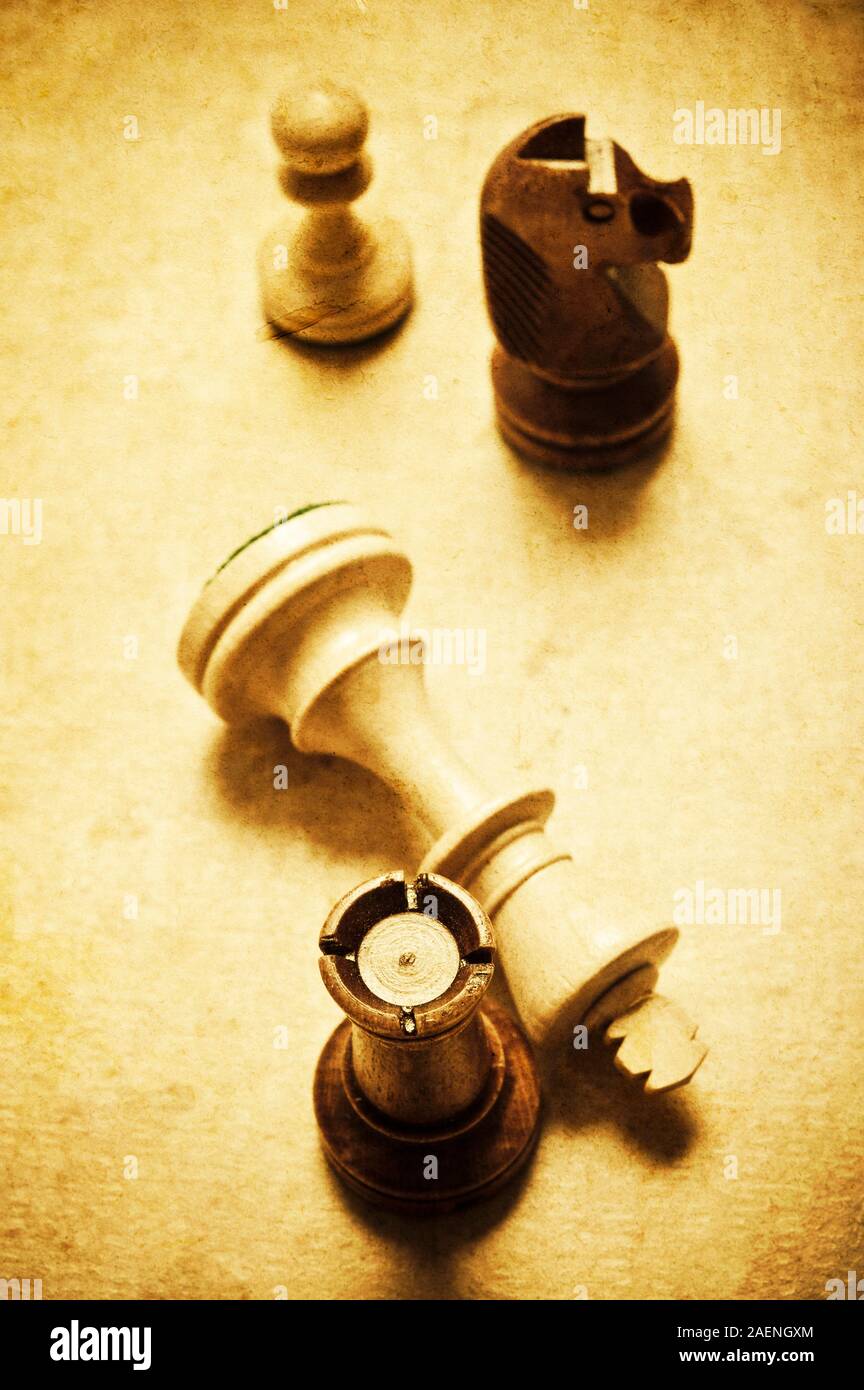 pieces of chess scattered on a grunge table around a chess king ...