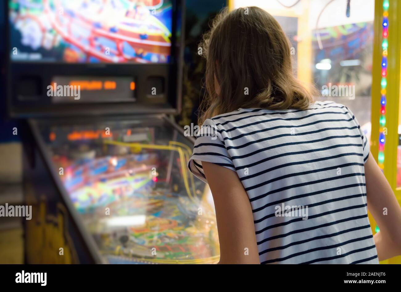 Little girl playing pinball game in theme park Stock Photo - Alamy