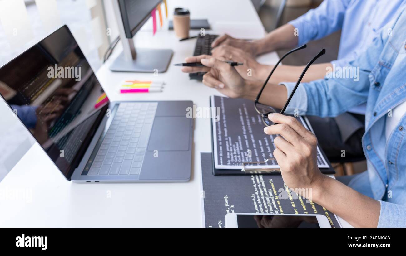 Young startup Programmers Sitting At Desks Working On Computers screen ...