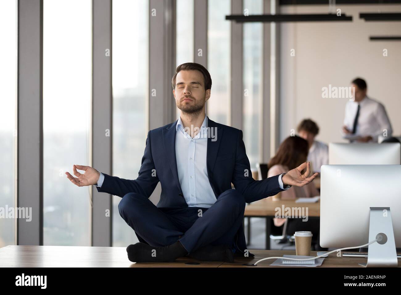Calm businessman meditating on office desk, stress relief concept Stock ...