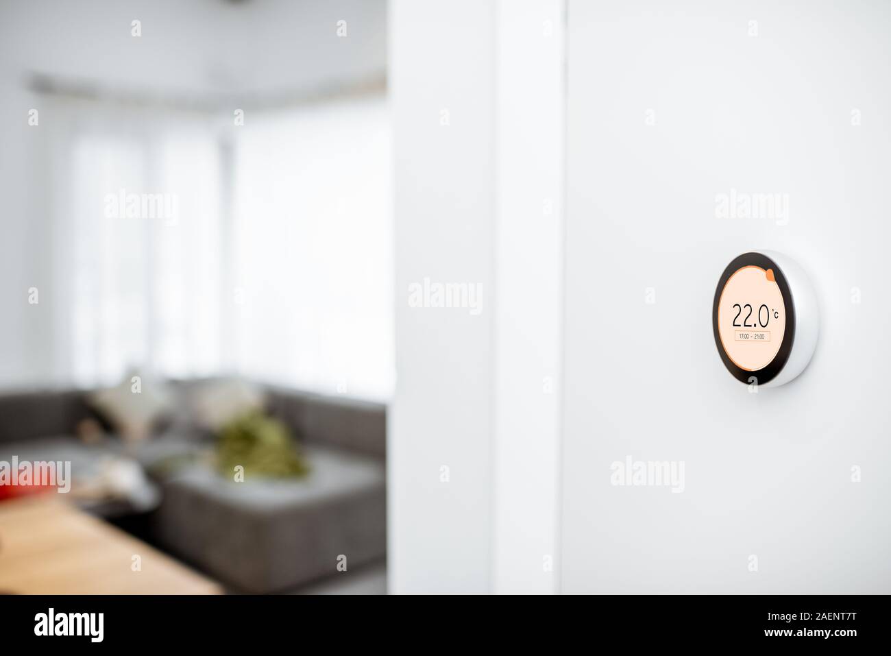 Round smart thermostat with touch screen installed on the wall indoors ...