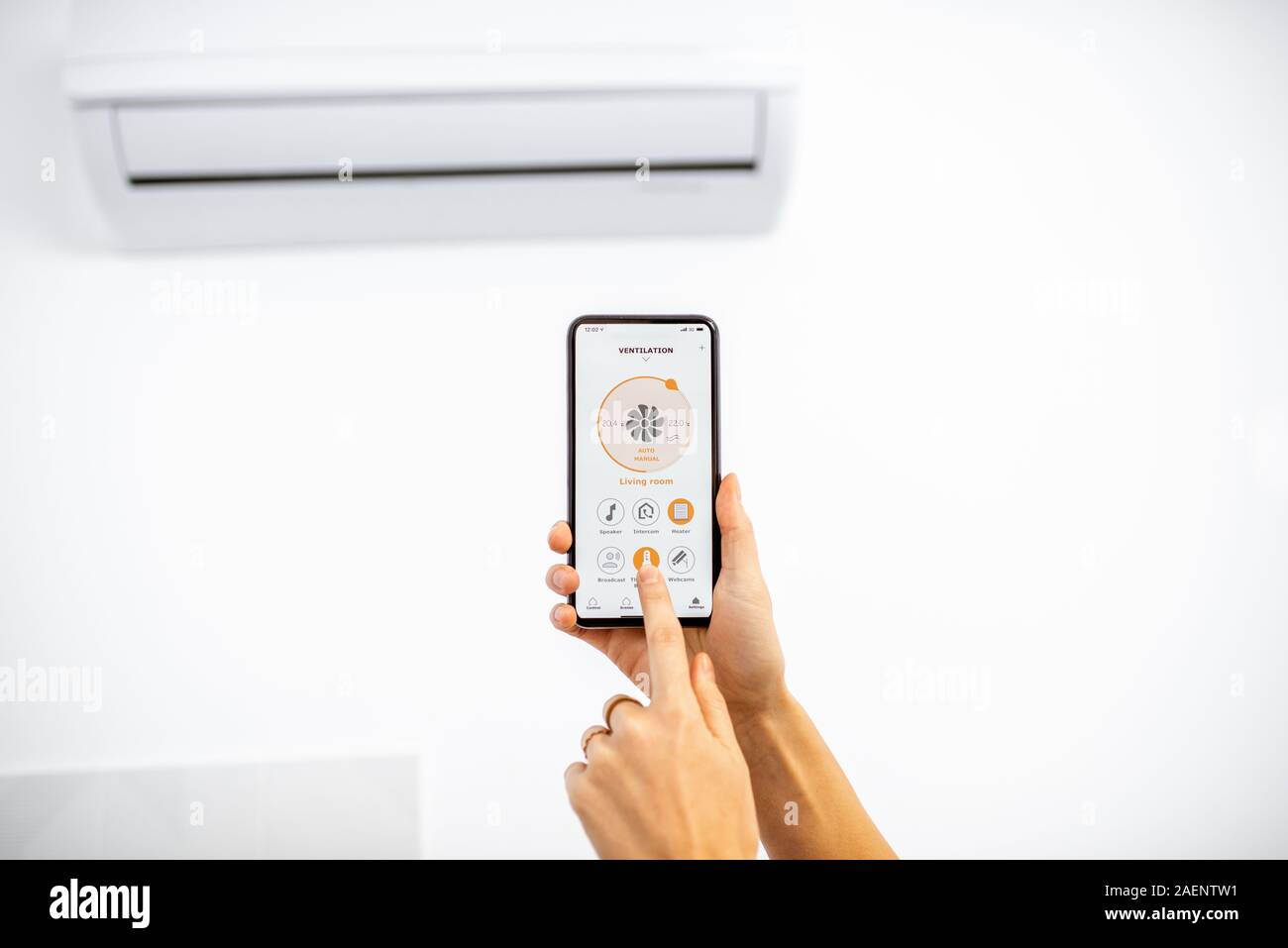 Controlling home conditioning with a smart phone, close-up. Concept of ...