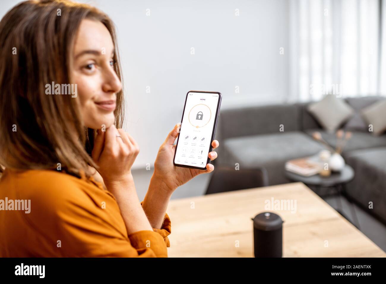 Young woman holding smart phone with launched security application at ...