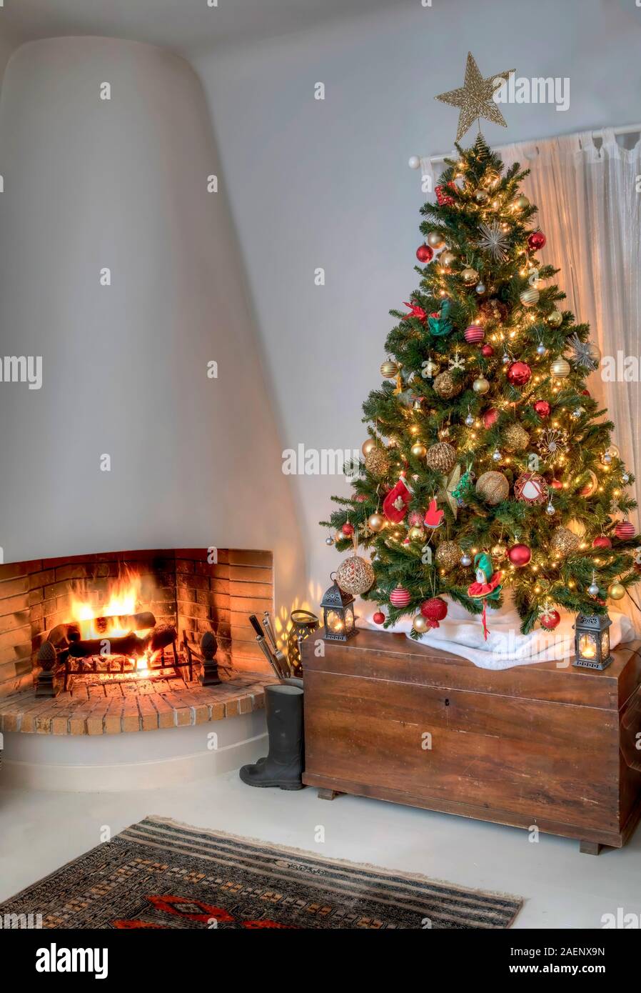 Festive decorated Christmas tree with a log fire burning in the ...