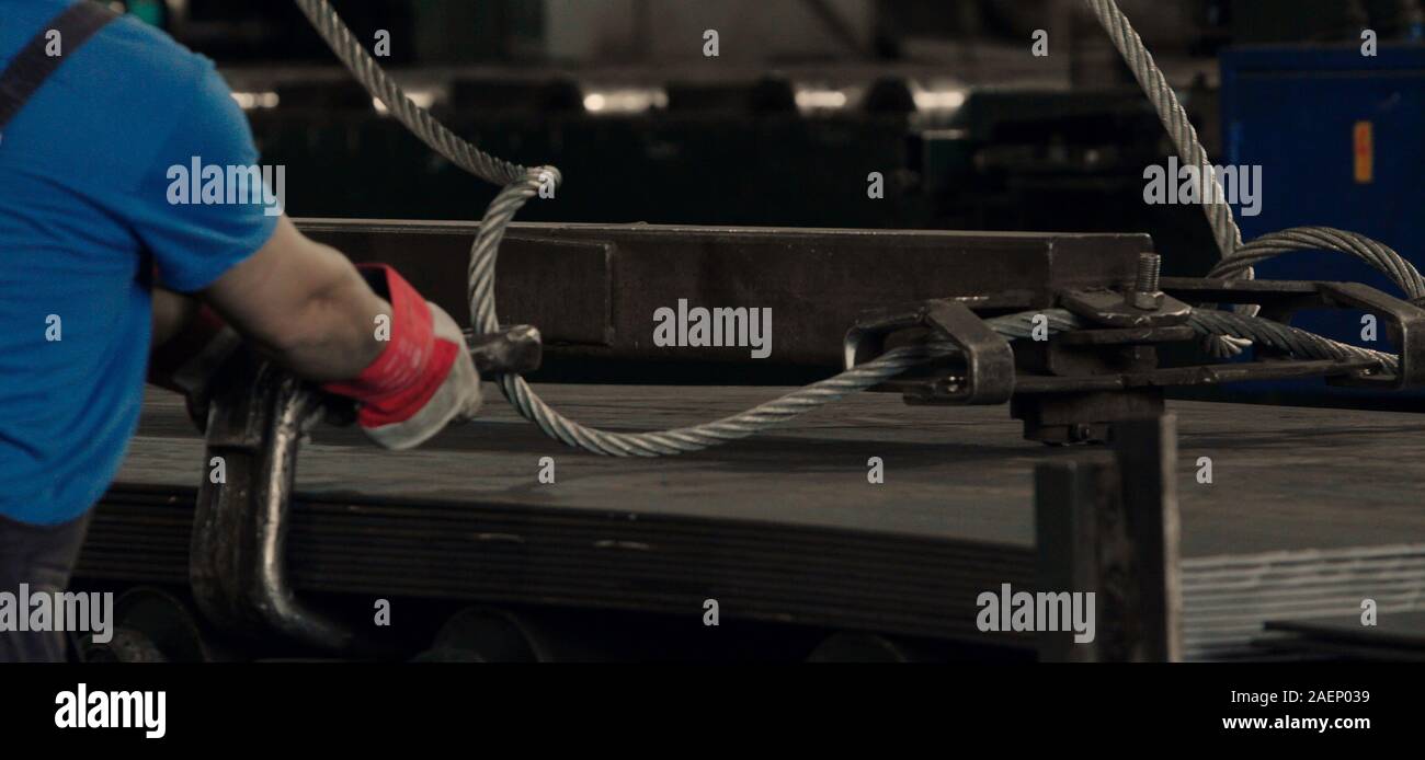 Worker installing big Wire Rope sling onto crane block in preparation ...