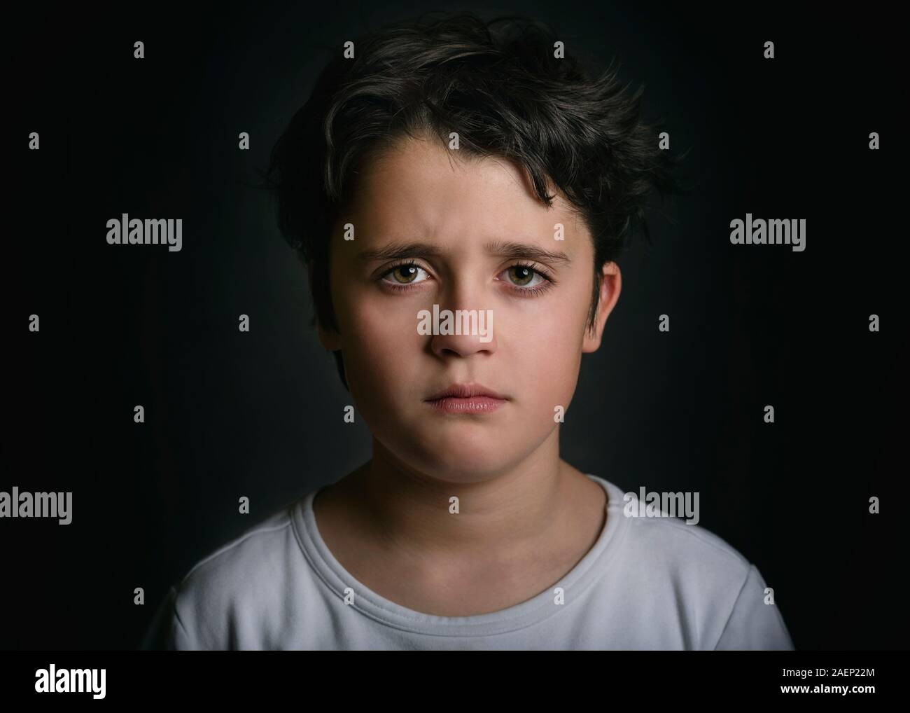 Portrait of sad child on black background Stock Photo - Alamy