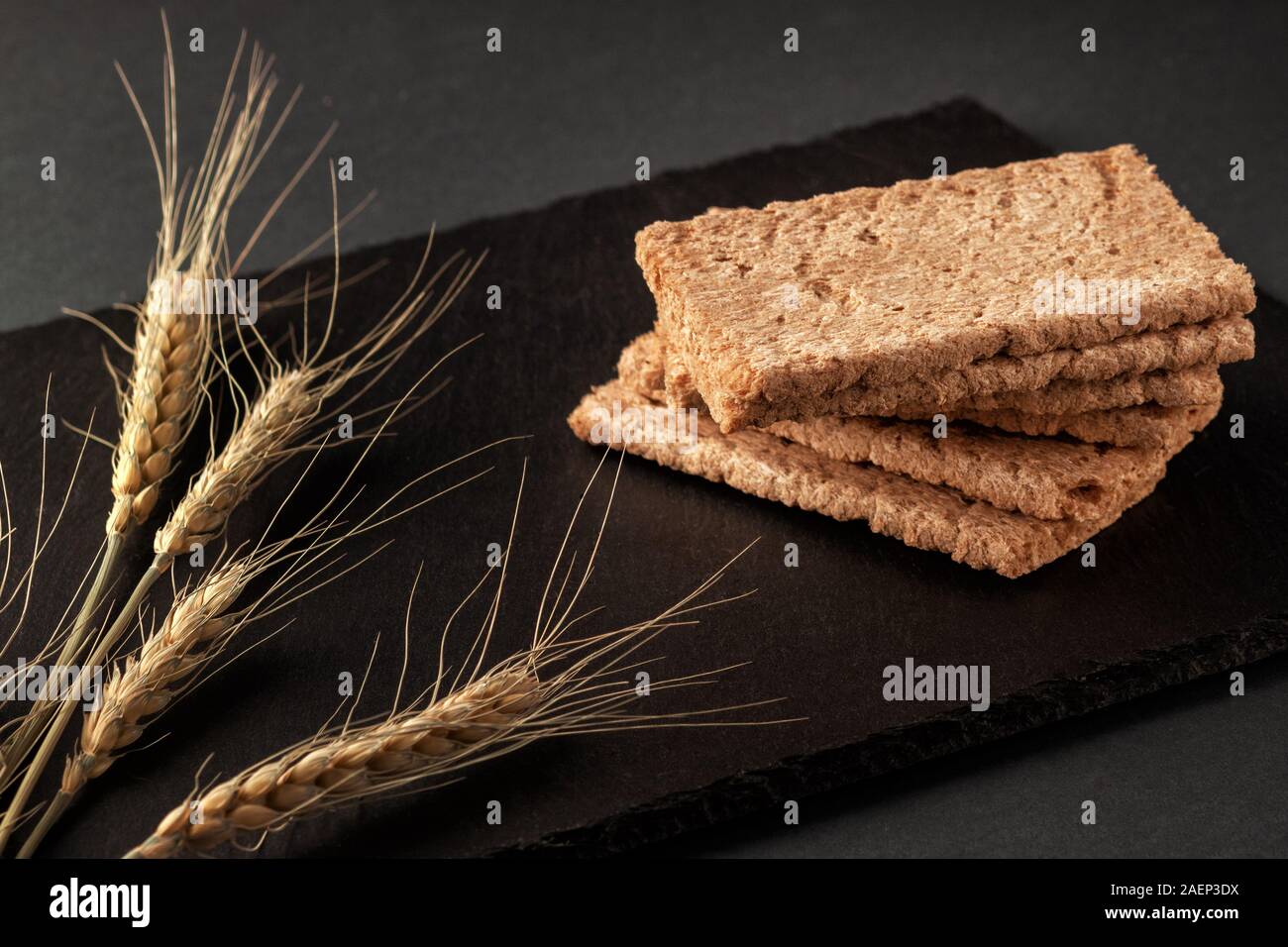Crispy rye bread on a serving board with rye ears Stock Photo - Alamy